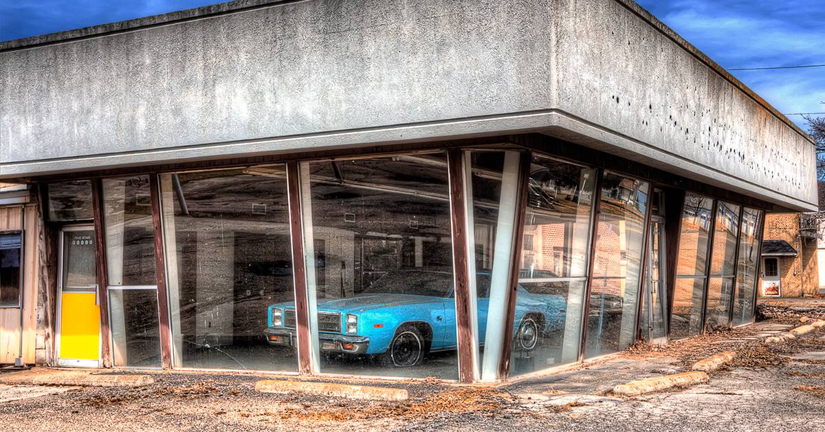 19 Eerie Pictures Of Abandoned Car Dealerships Around The World